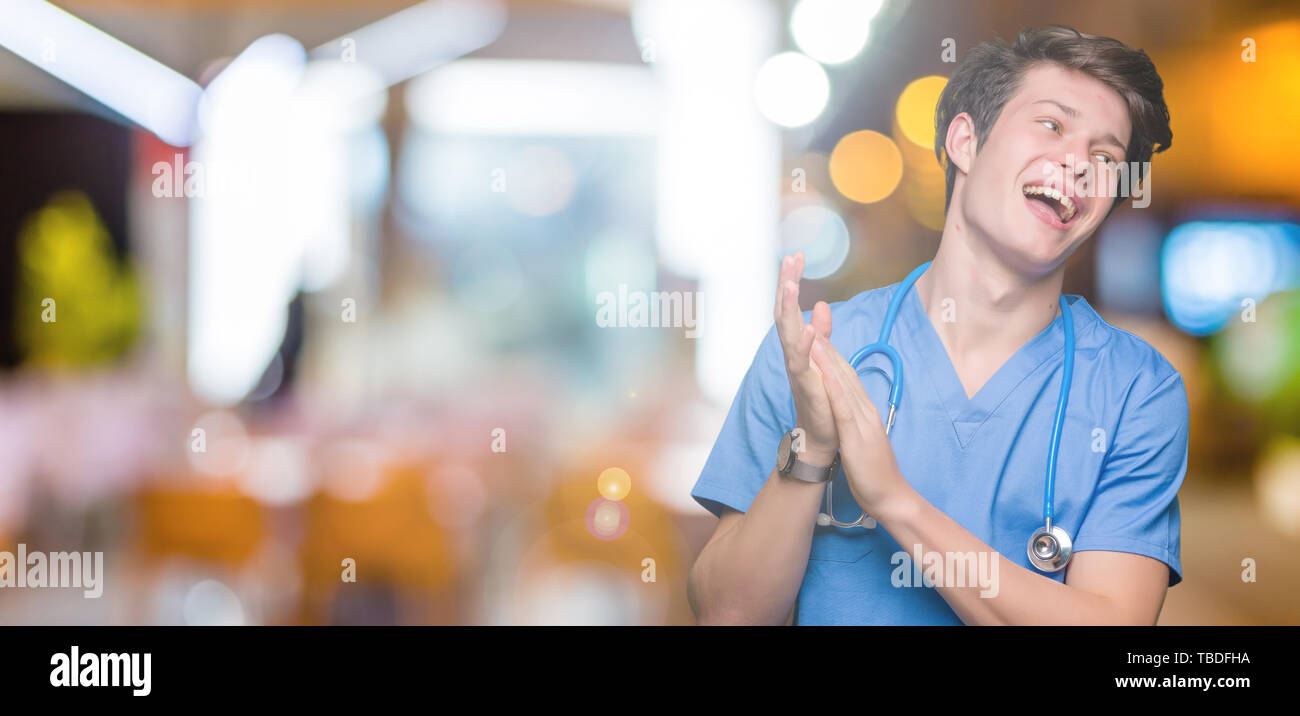 Young doctor wearing medical uniform over isolated background Clapping ...