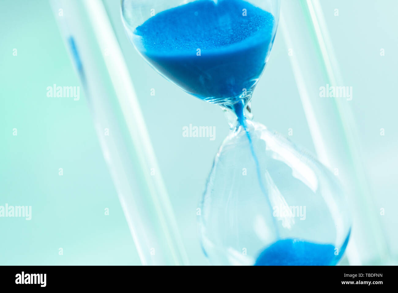 Time passing. Blue hourglass Stock Photo - Alamy