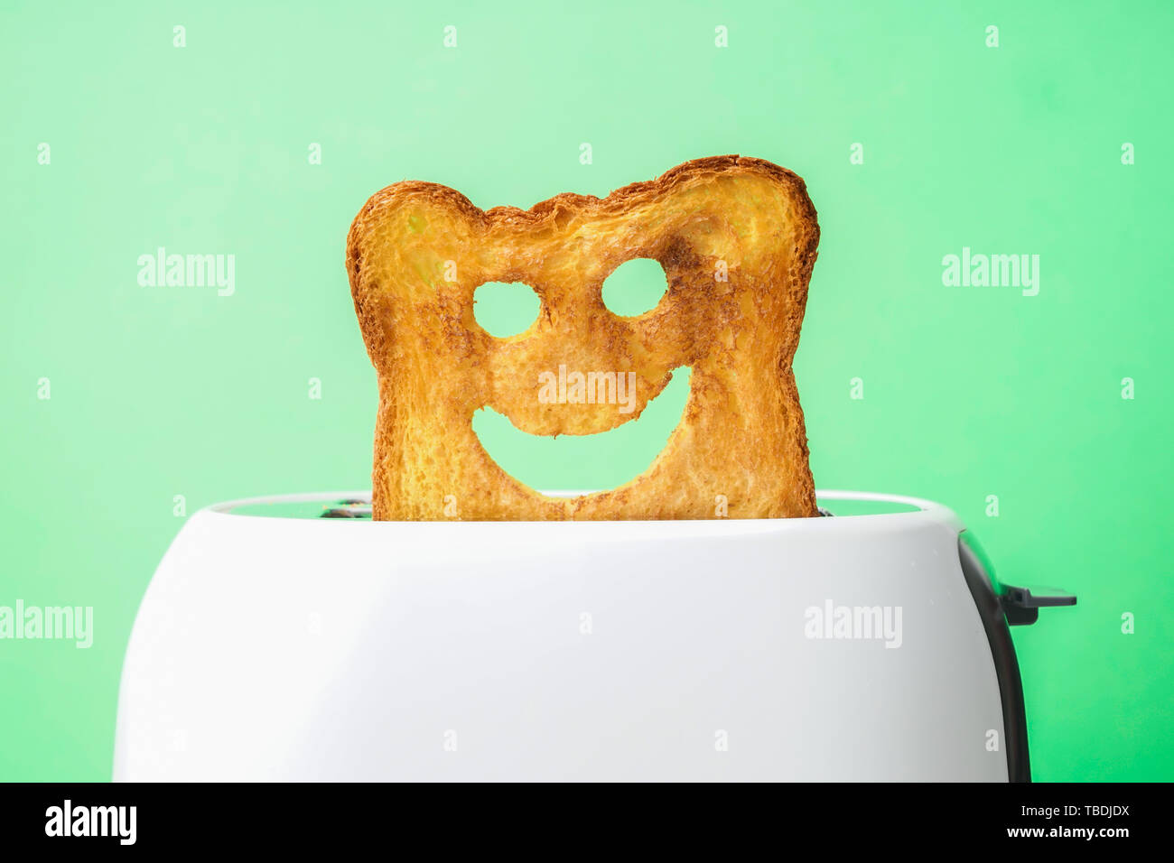 Funny slice of bread with toaster on color background Stock Photo - Alamy