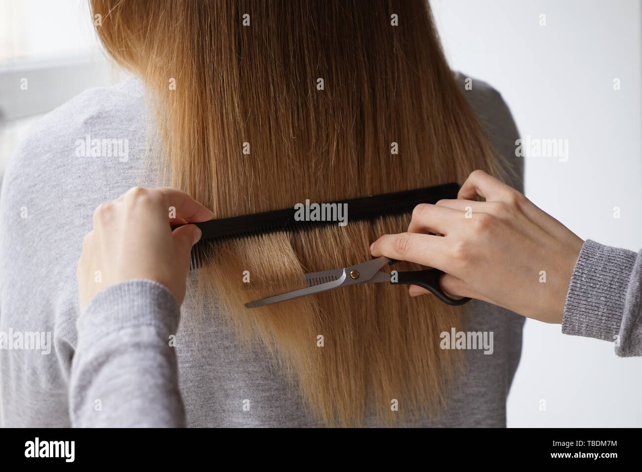 Woman cutting hair of her friend at home Stock Photo - Alamy