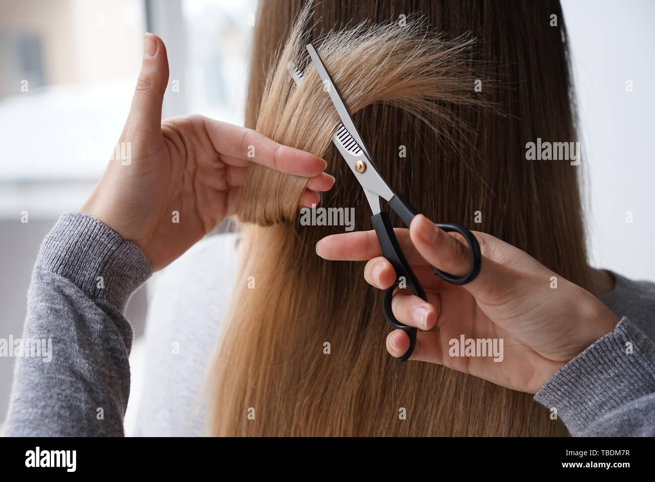 Woman cutting hair of her friend at home Stock Photo - Alamy