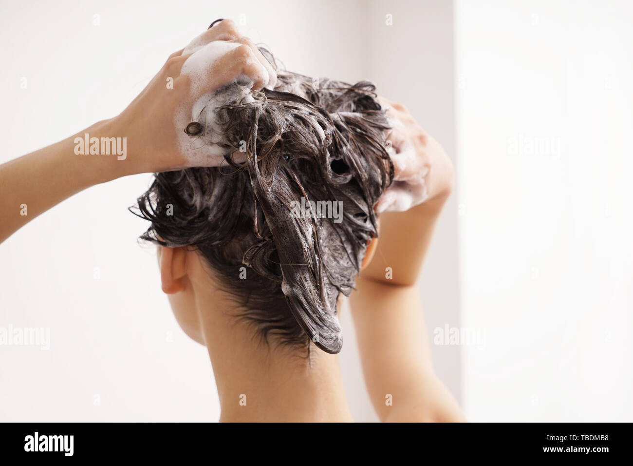 Young woman washing hair in bathroom Stock Photo - Alamy