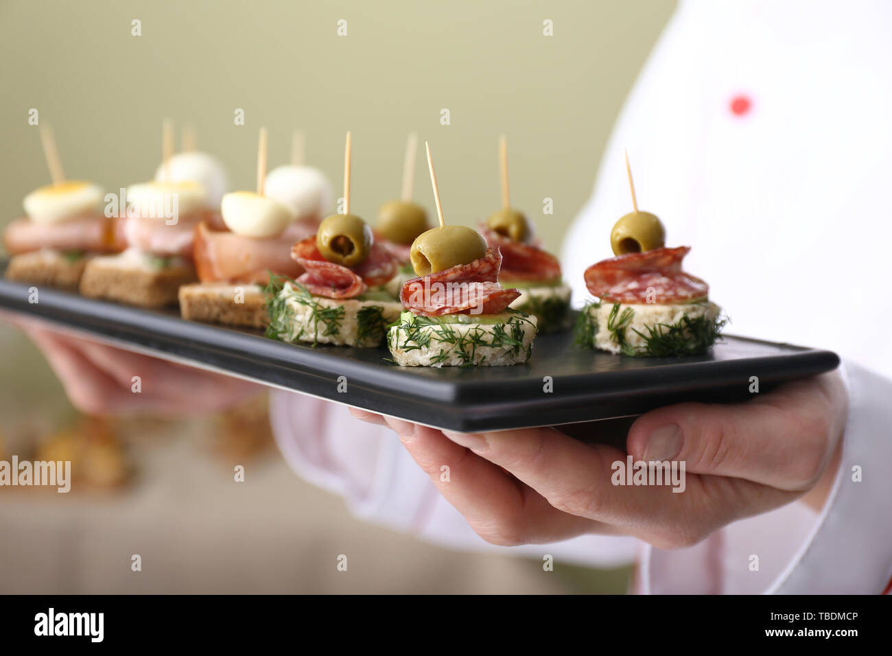 Chef holding plate with tasty canapes, closeup Stock Photo - Alamy