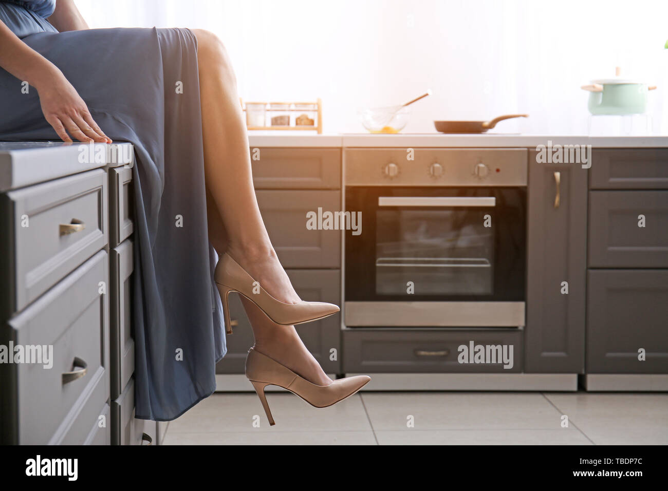 Woman sitting on counter hi-res stock photography and images - Alamy