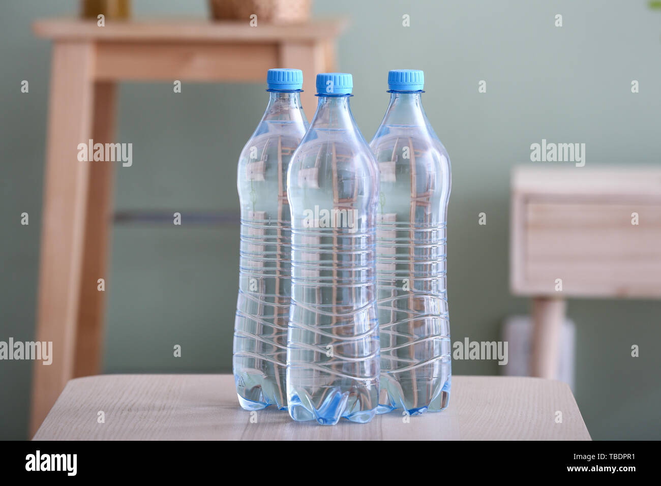 Bottles of water on table in room Stock Photo - Alamy