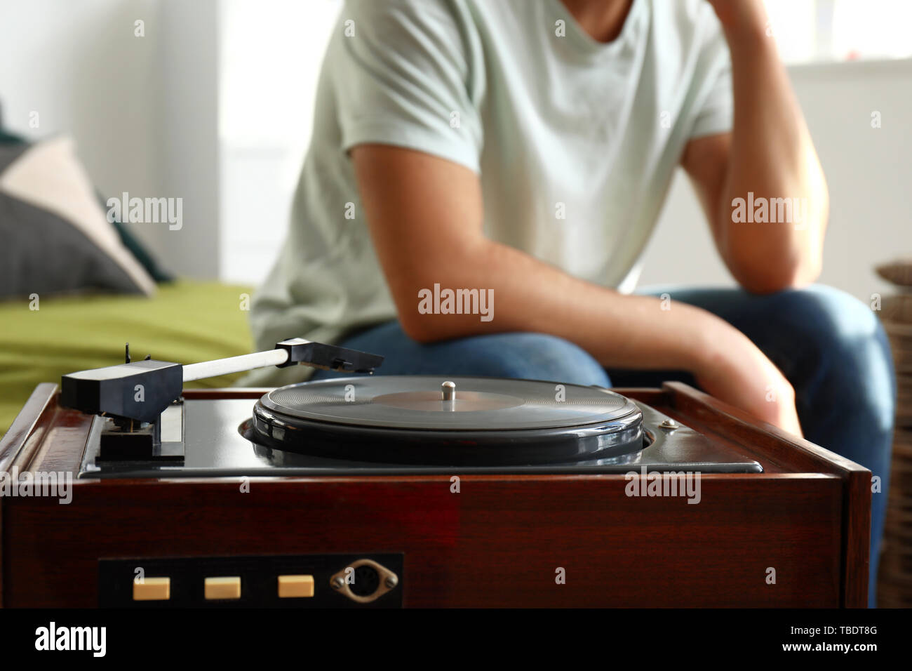 Young man listening to music on record player at home Stock Photo - Alamy