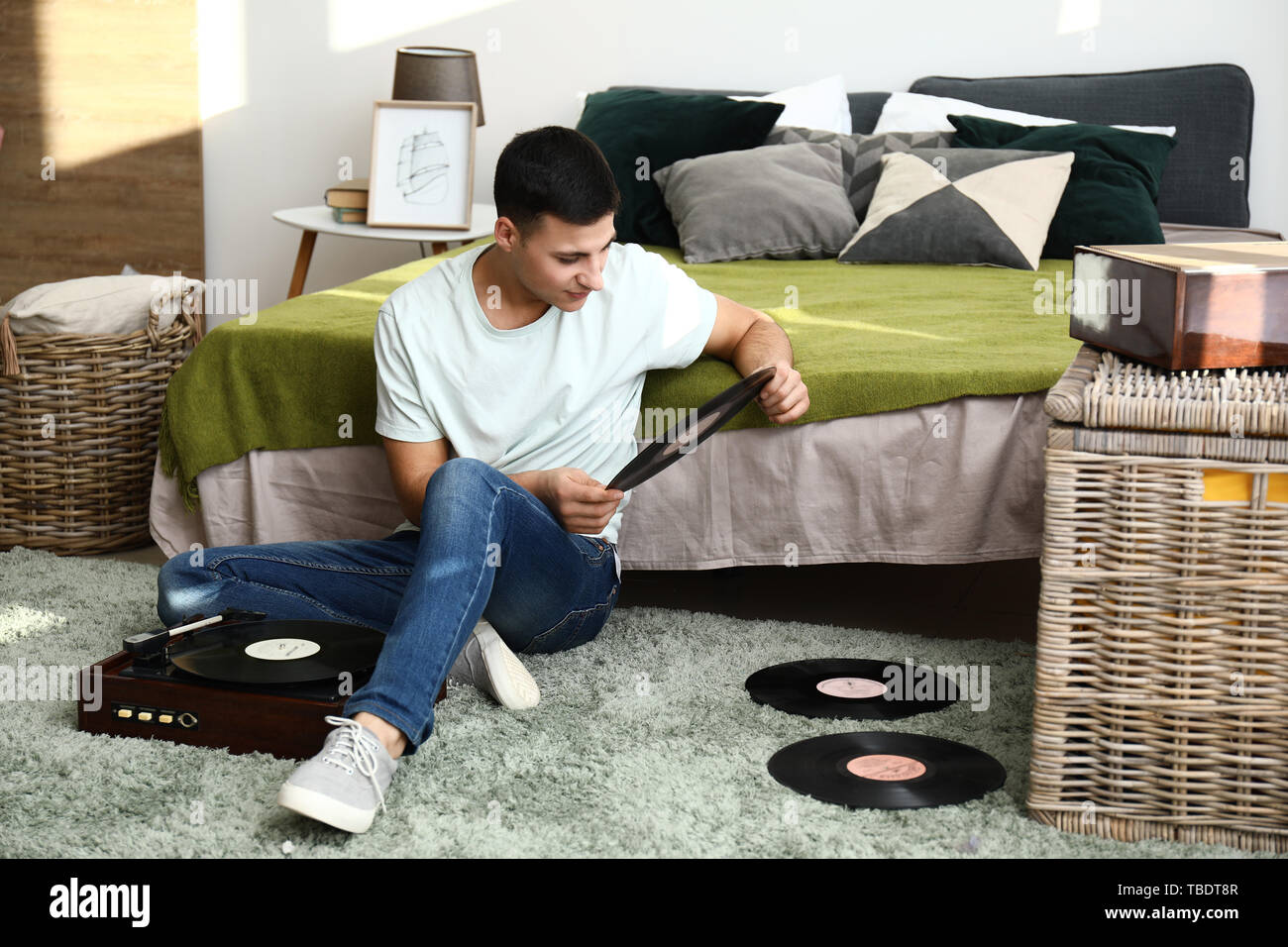 Young man listening to music on record player at home Stock Photo - Alamy