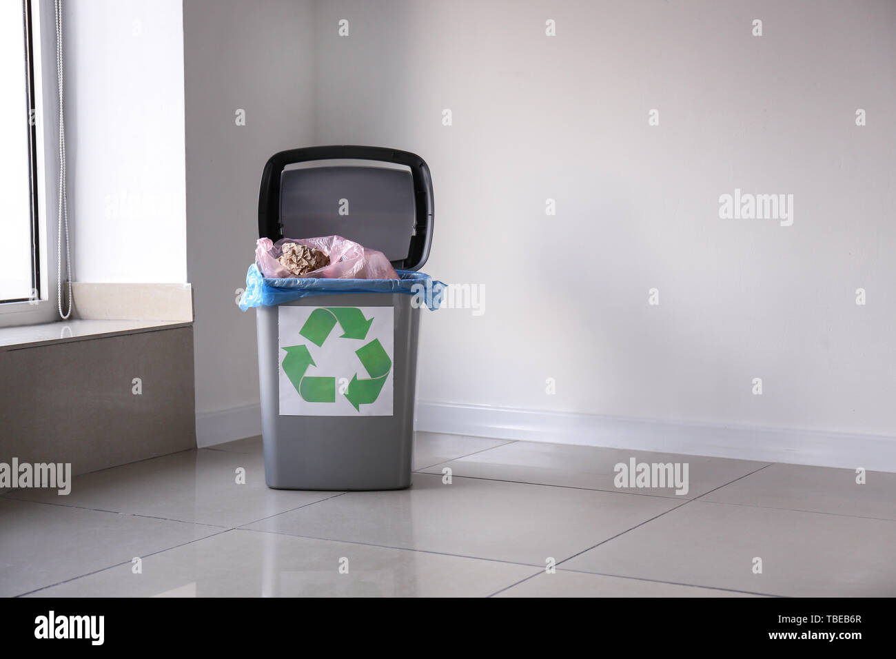 Trash bin with garbage indoors. Recycling concept Stock Photo - Alamy