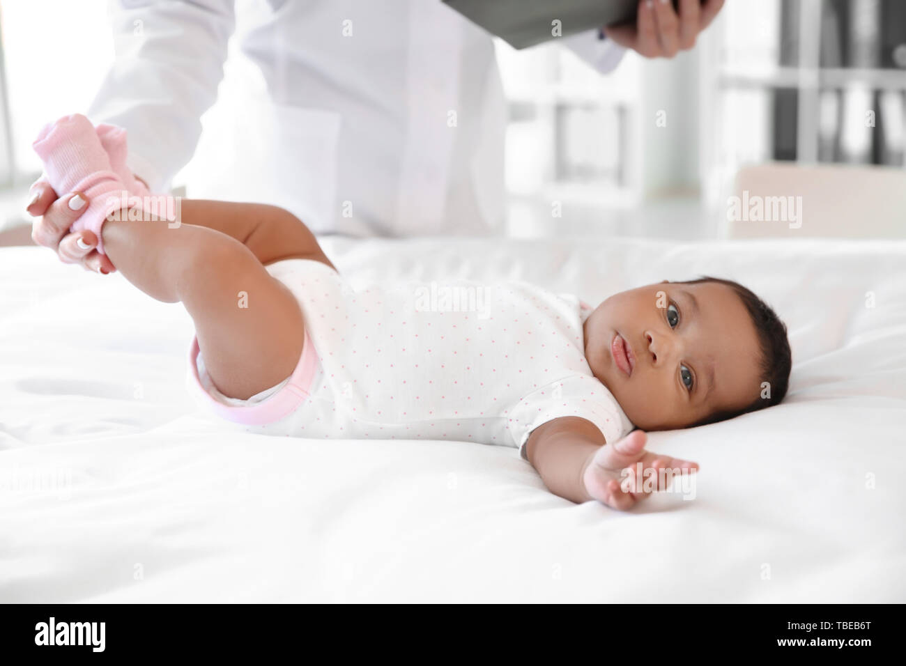 Pediatrician examining African-American baby in clinic Stock Photo - Alamy