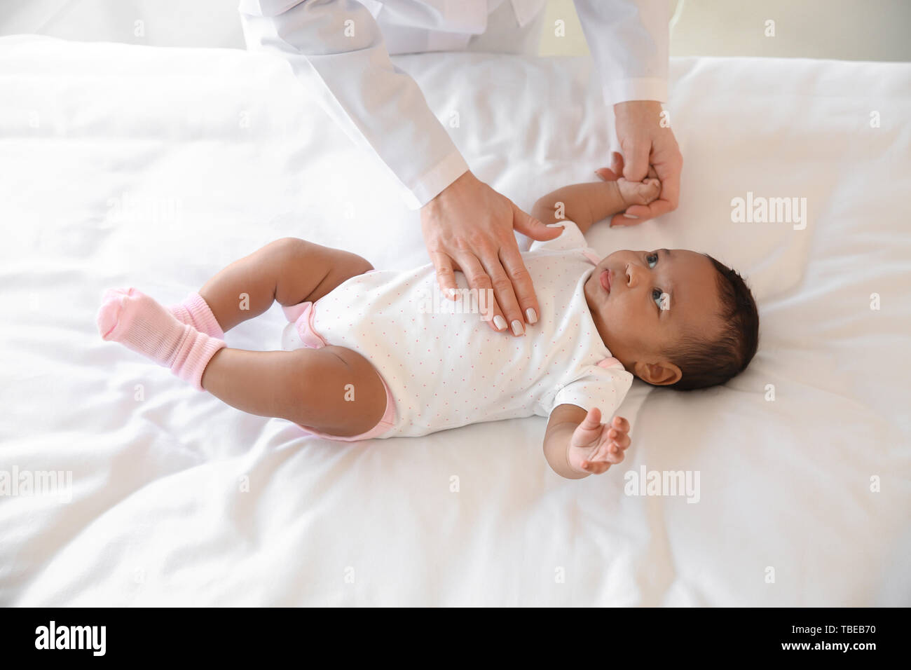 Pediatrician examining African-American baby in clinic Stock Photo - Alamy