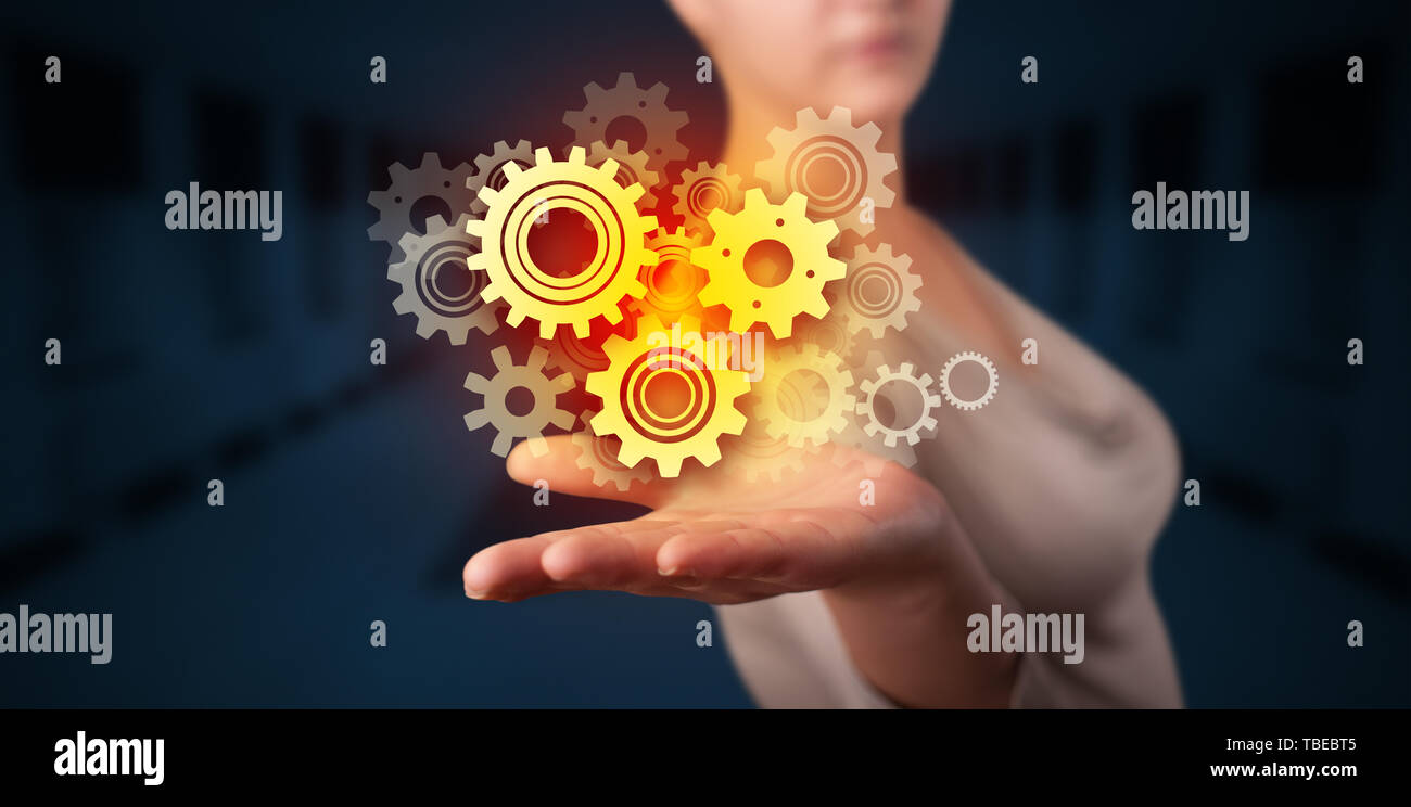 Hand holding gears in his hand Stock Photo - Alamy