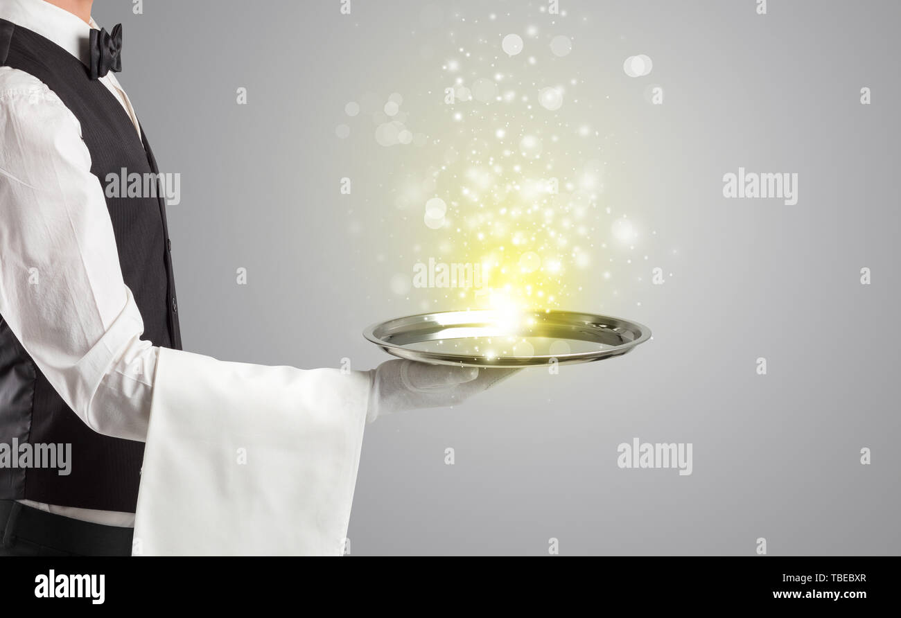 Elegant young waiter serving mysterious light on tray Stock Photo - Alamy