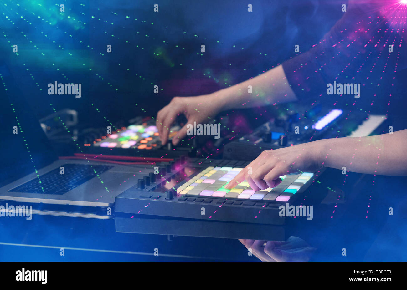Hand mixing music on midi controller with party club colors around ...