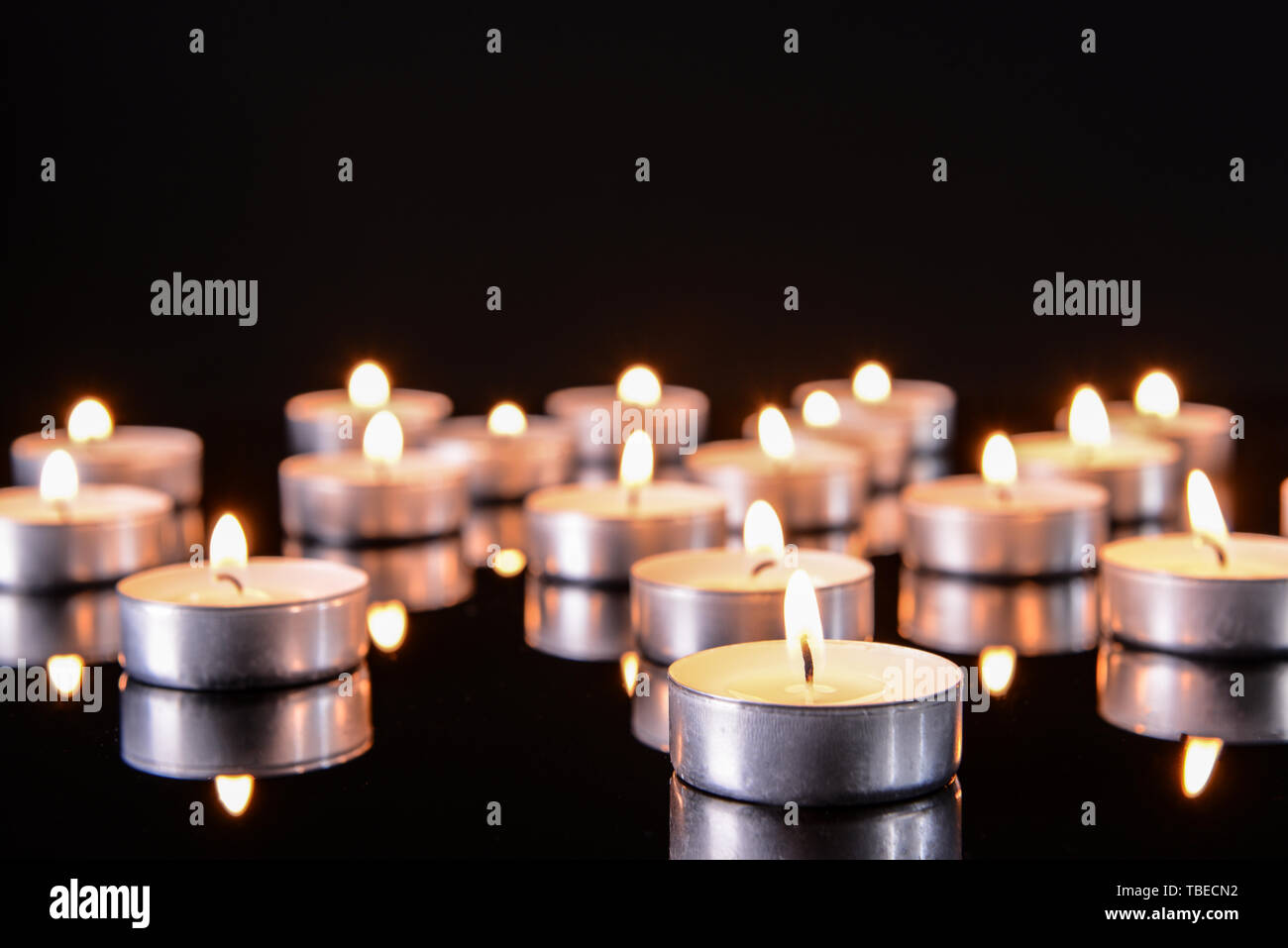 Many burning candles as symbol of mourning on dark background Stock ...