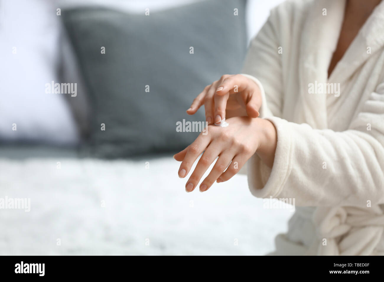Young woman applying hand cream at home Stock Photo - Alamy