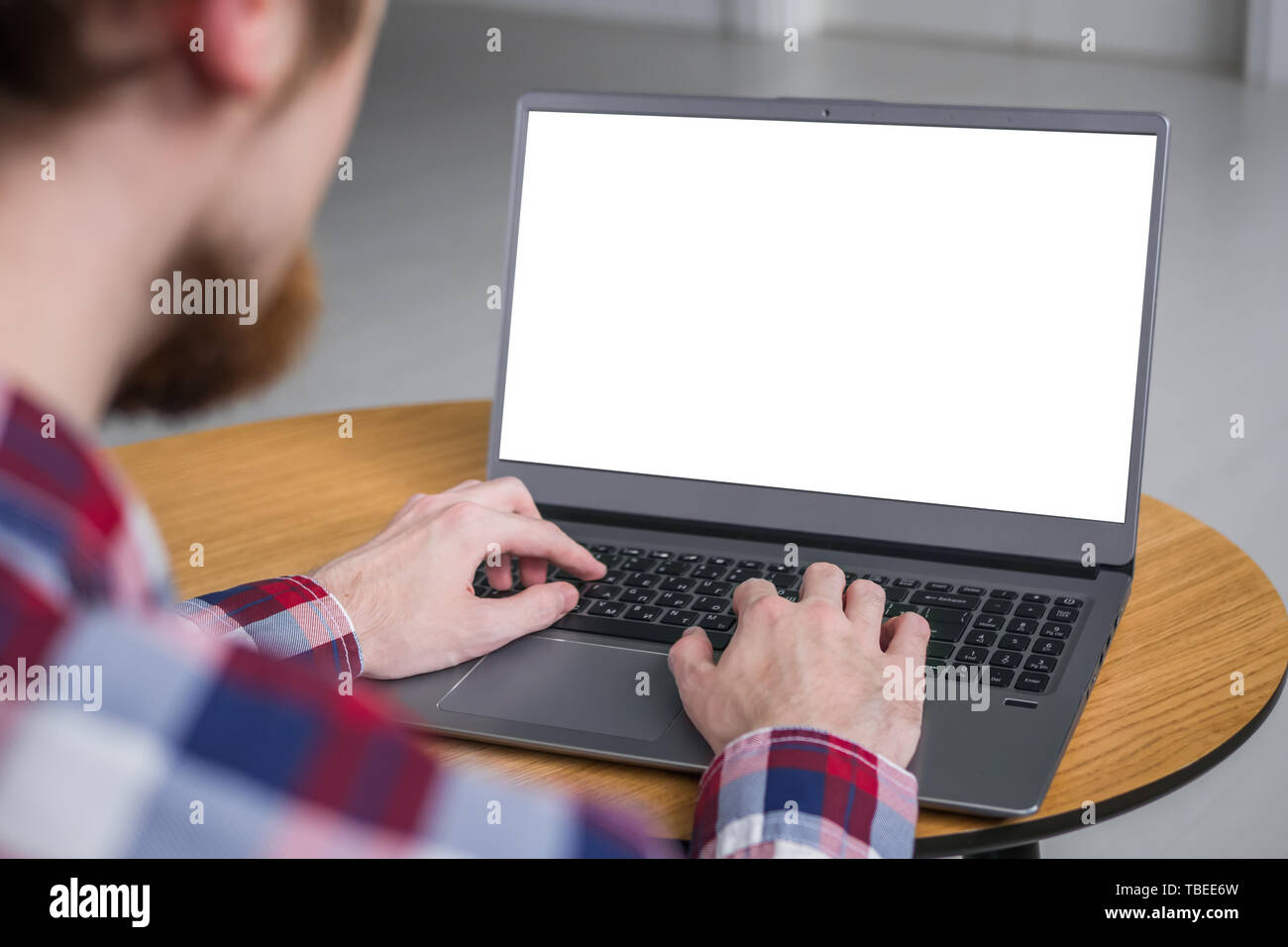 Man student typing on grey laptop computer keyboard with white blank ...