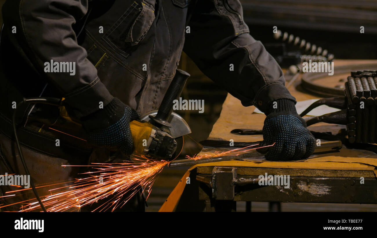 Blacksmith sawing metal with hand circular saw Stock Photo - Alamy