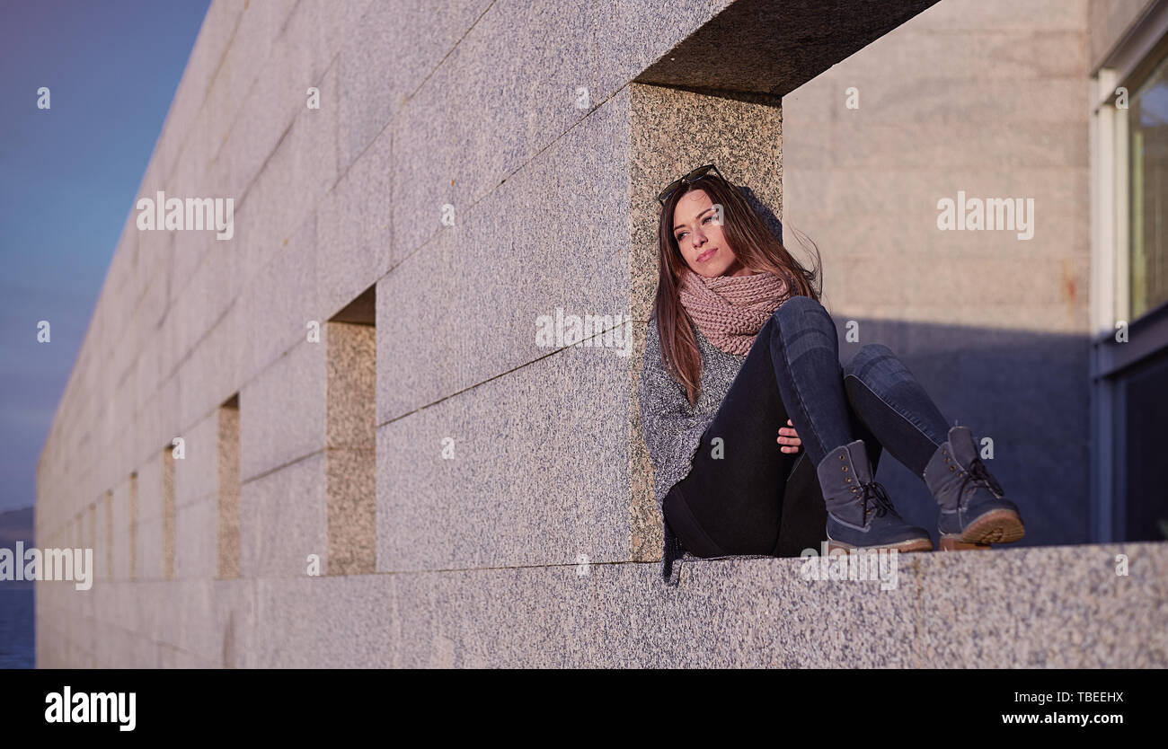 Young woman enjoying the sunlight in a square shaped window made of ...