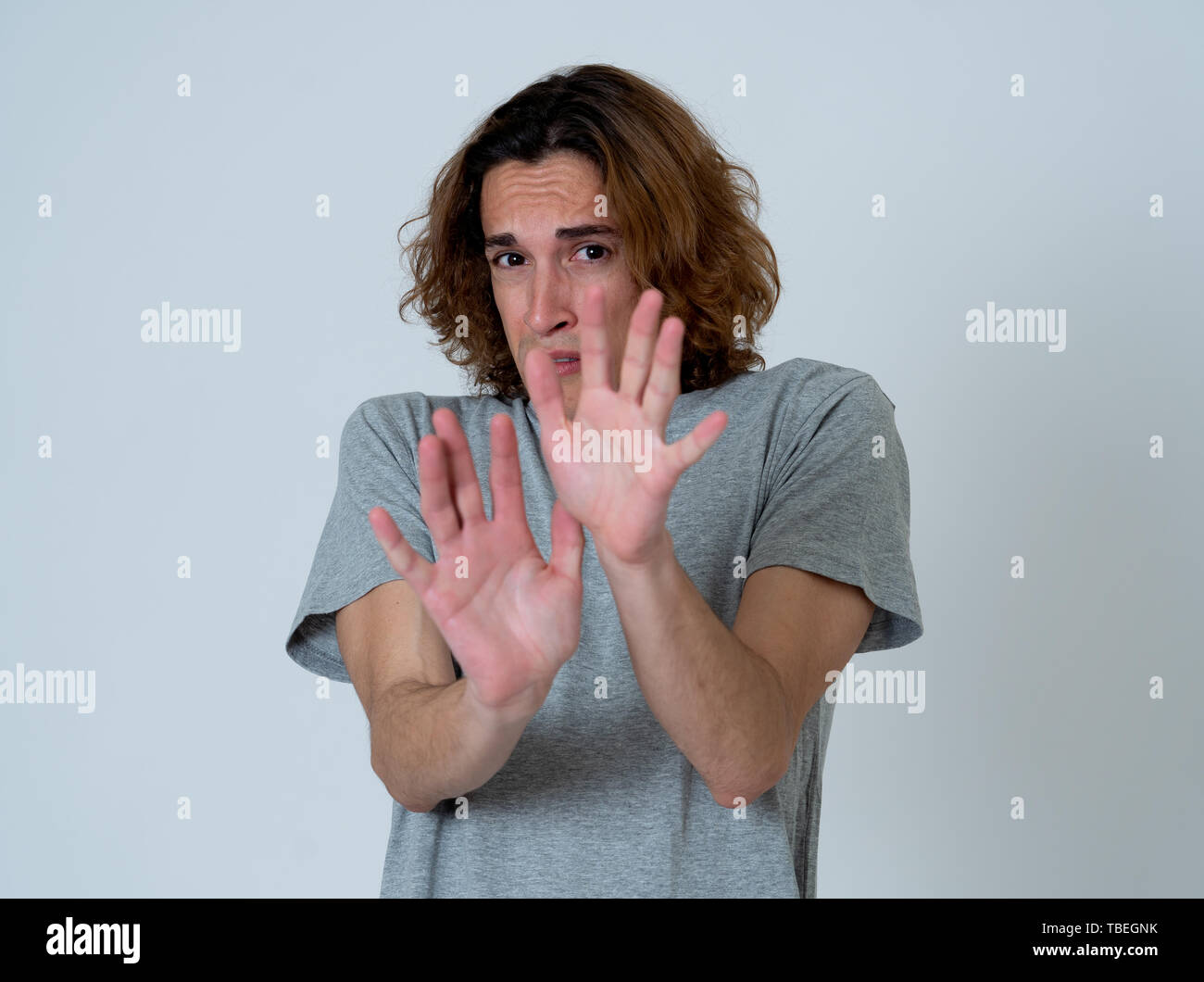 Young man feeling frightened and shocked making scared gestures in fear ...