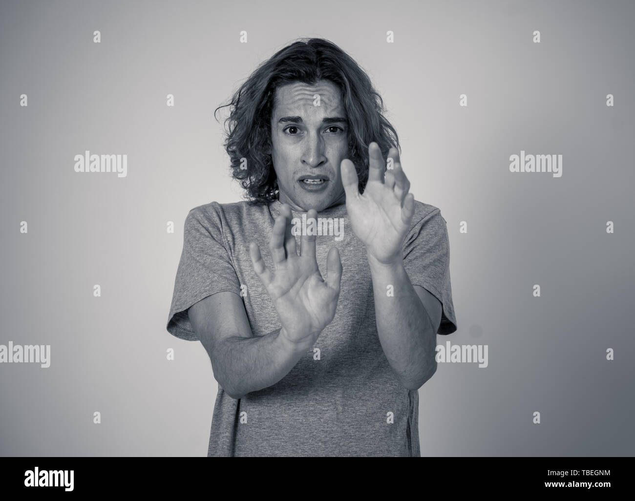 Young man feeling frightened and shocked making scared gestures in fear ...