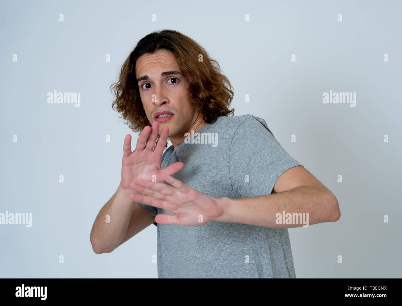 Young man feeling frightened and shocked making scared gestures in fear ...