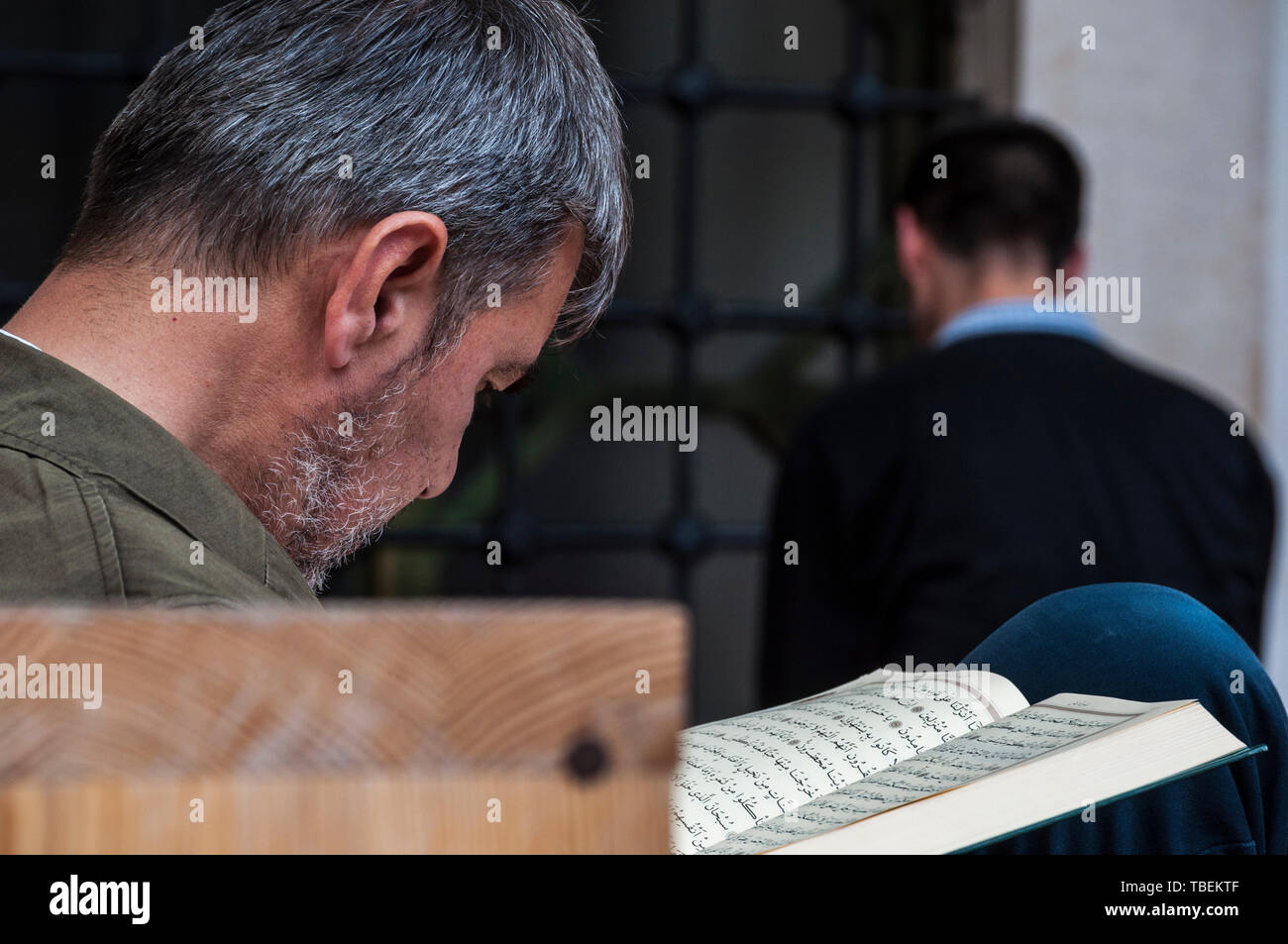 Sarajevo, Bosnia: a muslim man reading the Quran near a brother praying ...