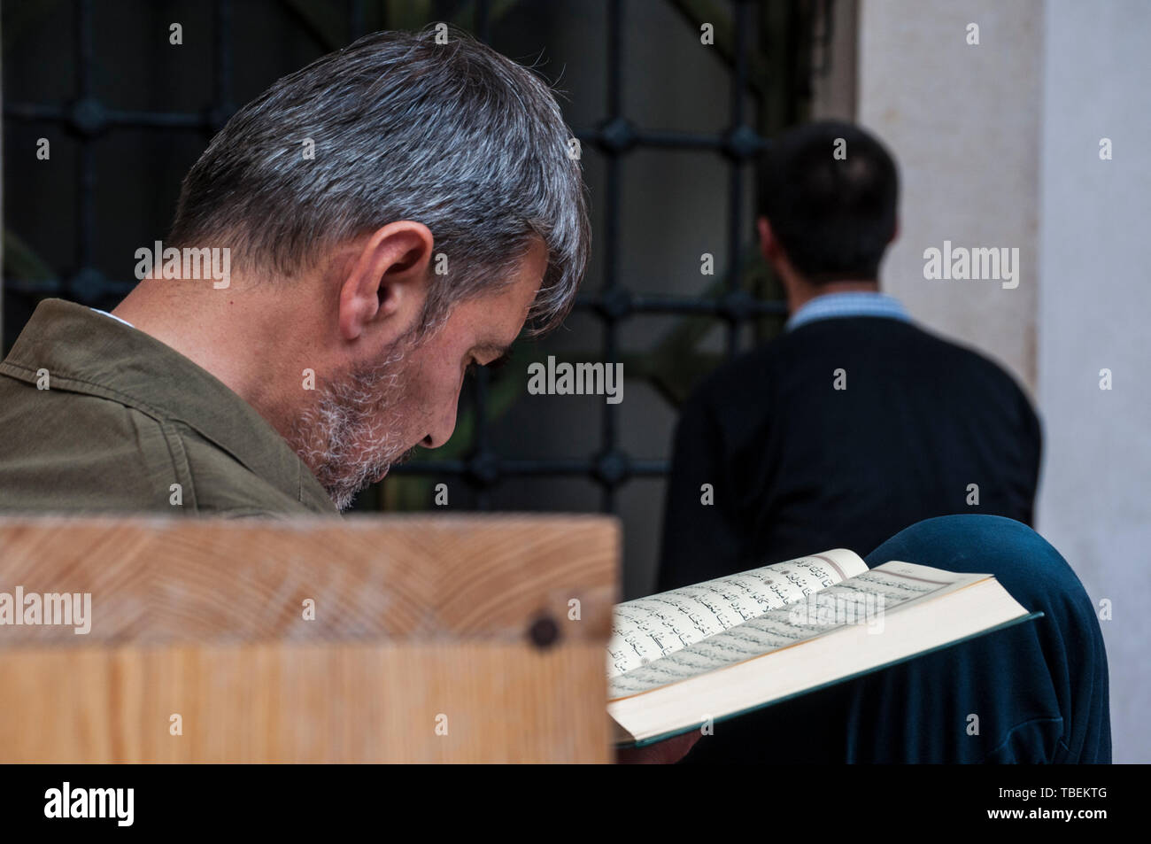 Sarajevo, Bosnia: a muslim man reading the Quran near a brother praying ...