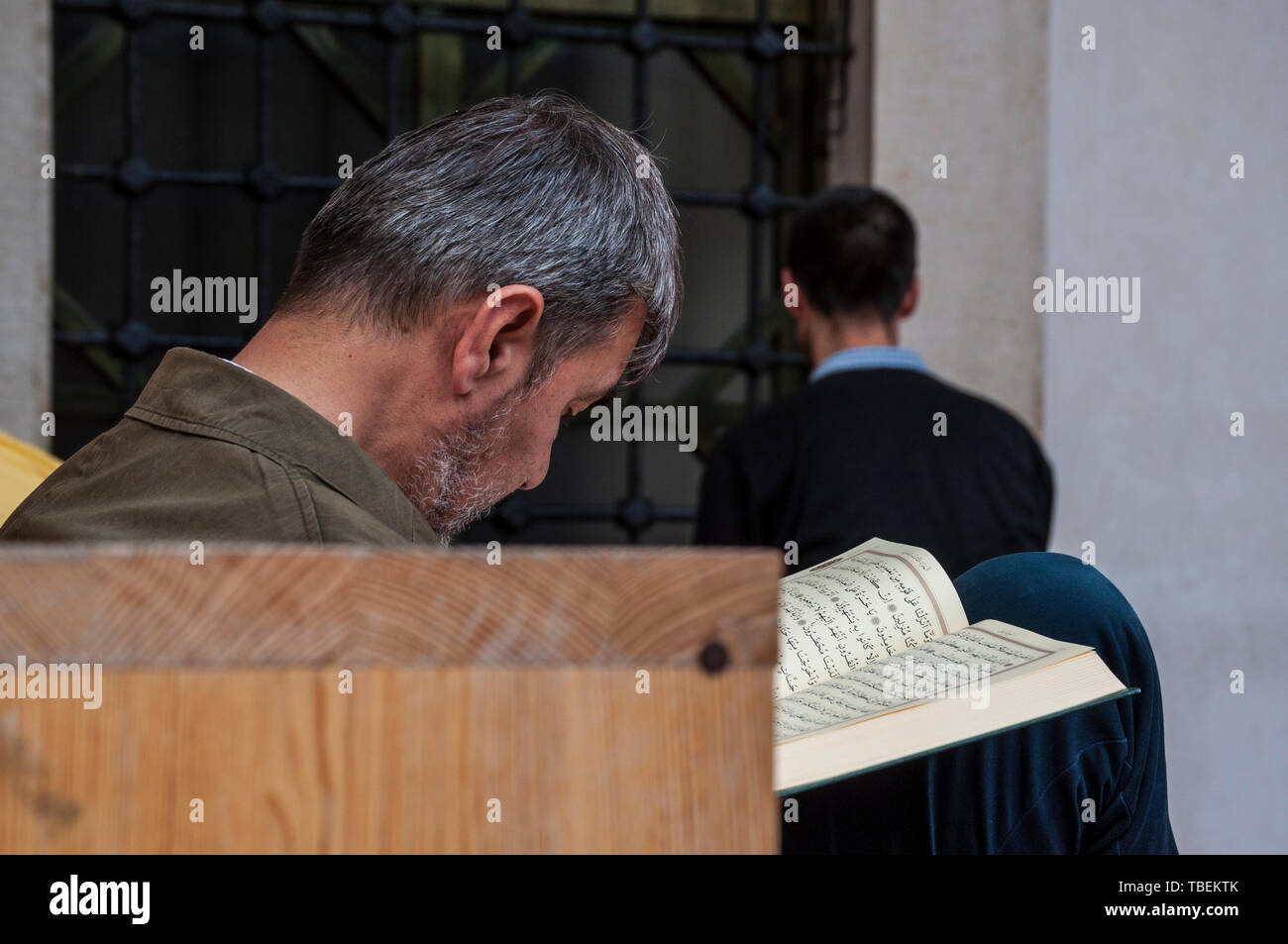 Sarajevo, Bosnia: a muslim man reading the Quran near a brother praying ...