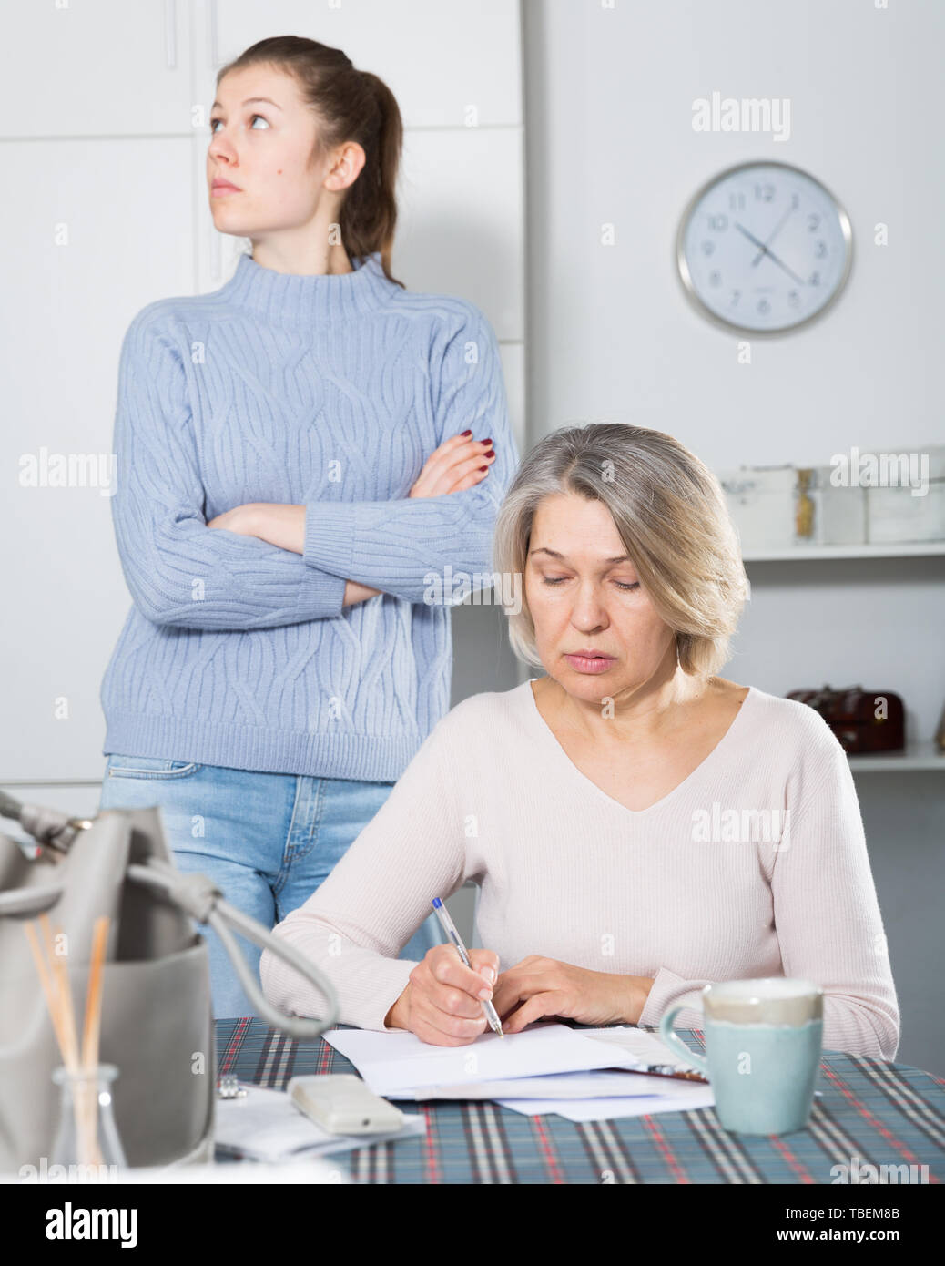 Outraged adult daughter having disagreement with her mother for ...