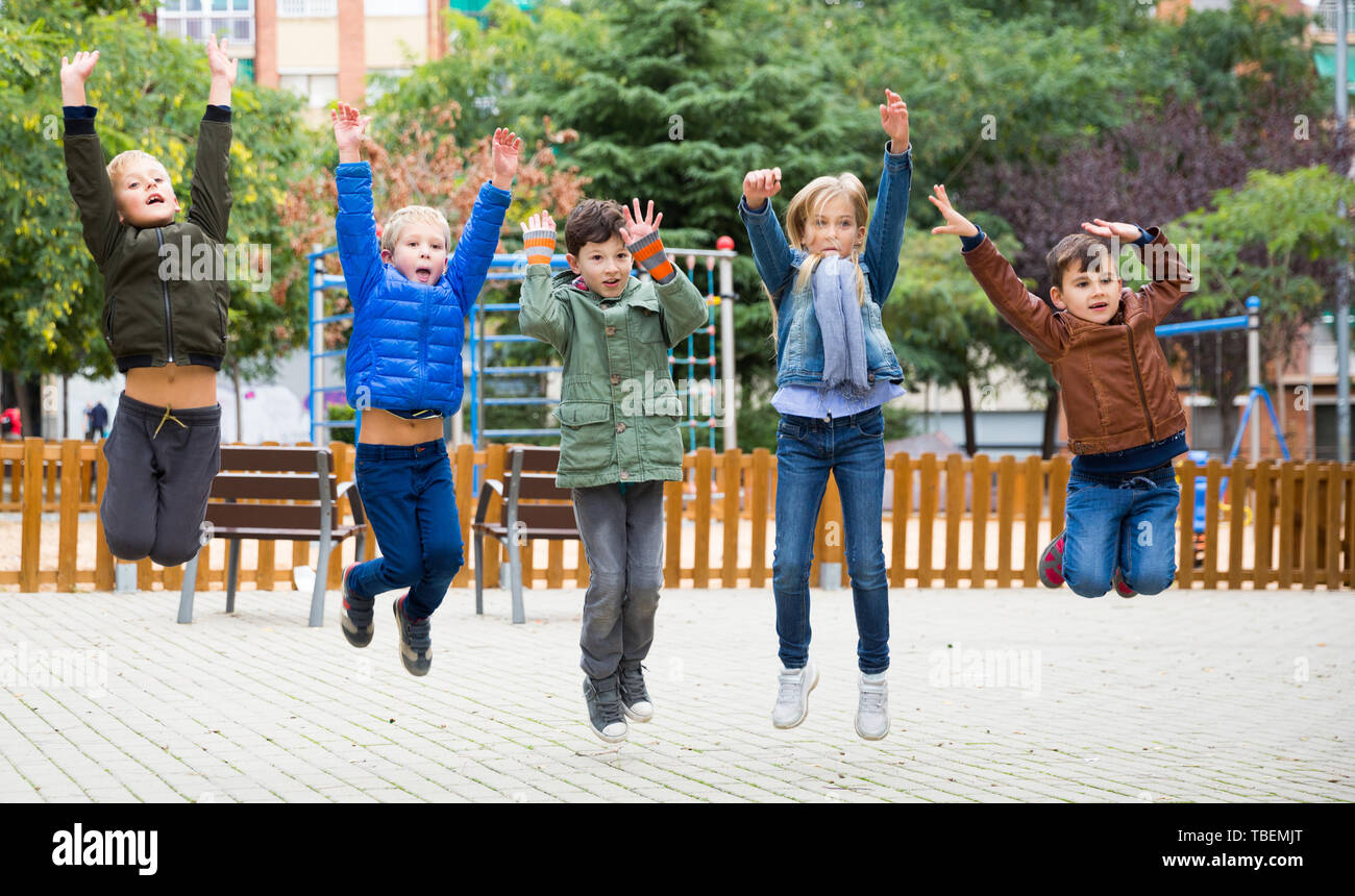 Happy kids jump and play outside Stock Photo - Alamy