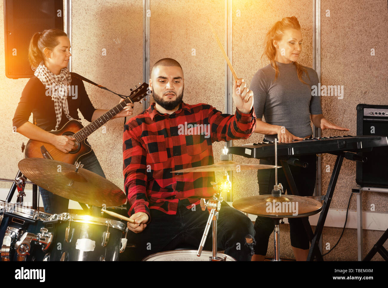 Expressive cheerful positive smiling drummer with his bandmates ...