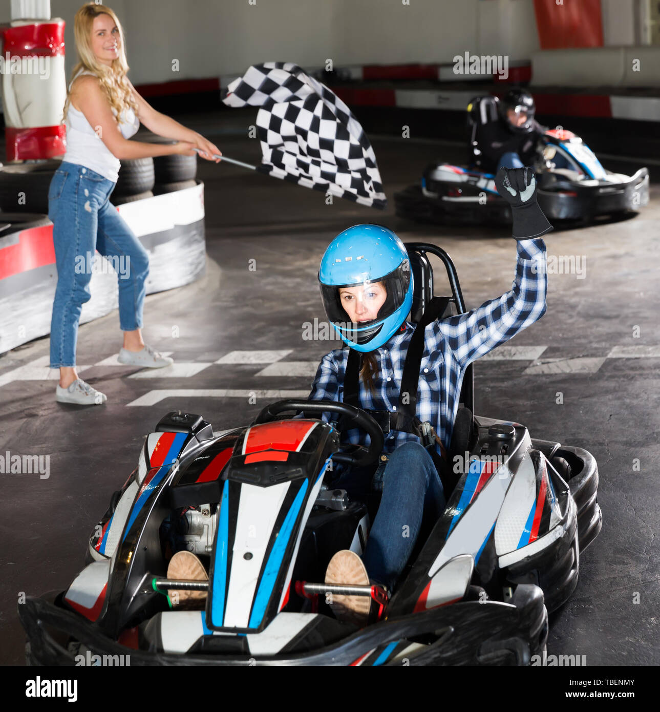 Glad adult female go-cart racer crossing finish line Stock Photo - Alamy