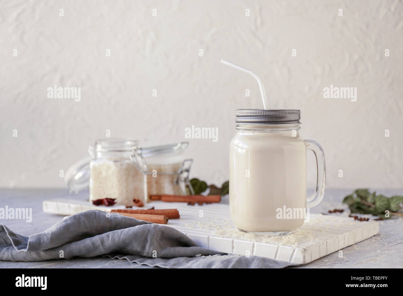 Mason jar of healthy rice milk on table Stock Photo - Alamy