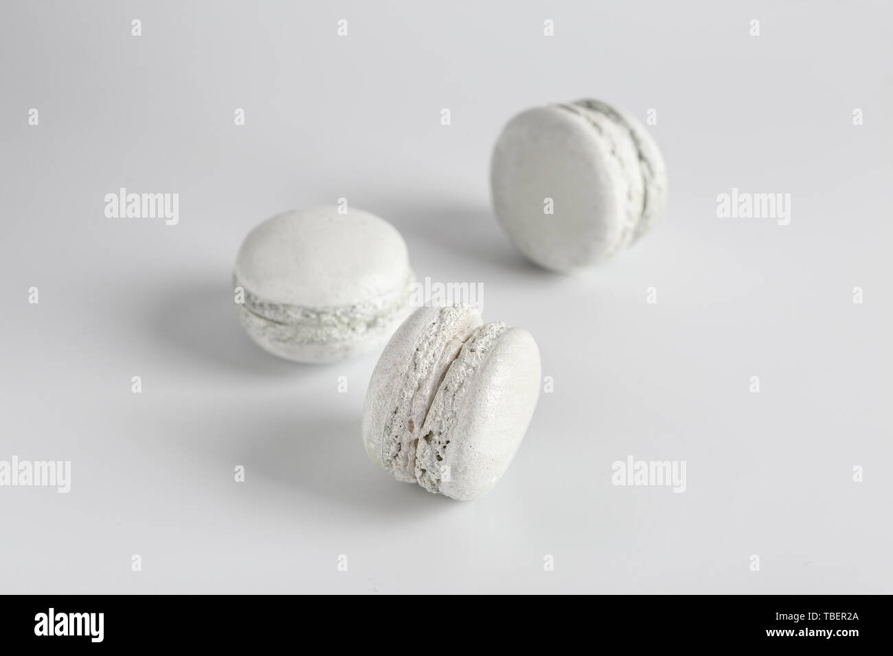 White macarons on light background Stock Photo - Alamy