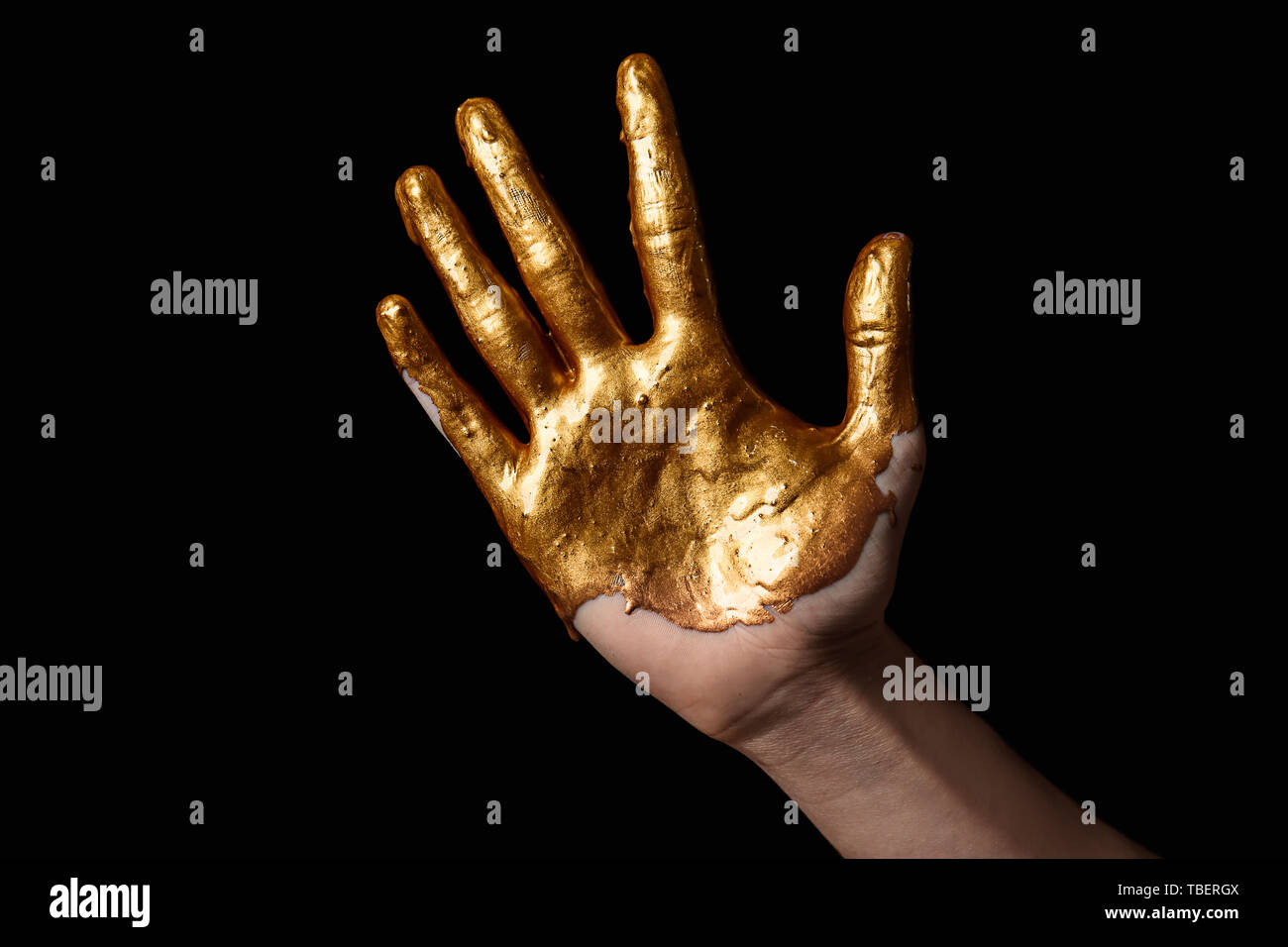 Female hand with golden paint against dark background Stock Photo - Alamy