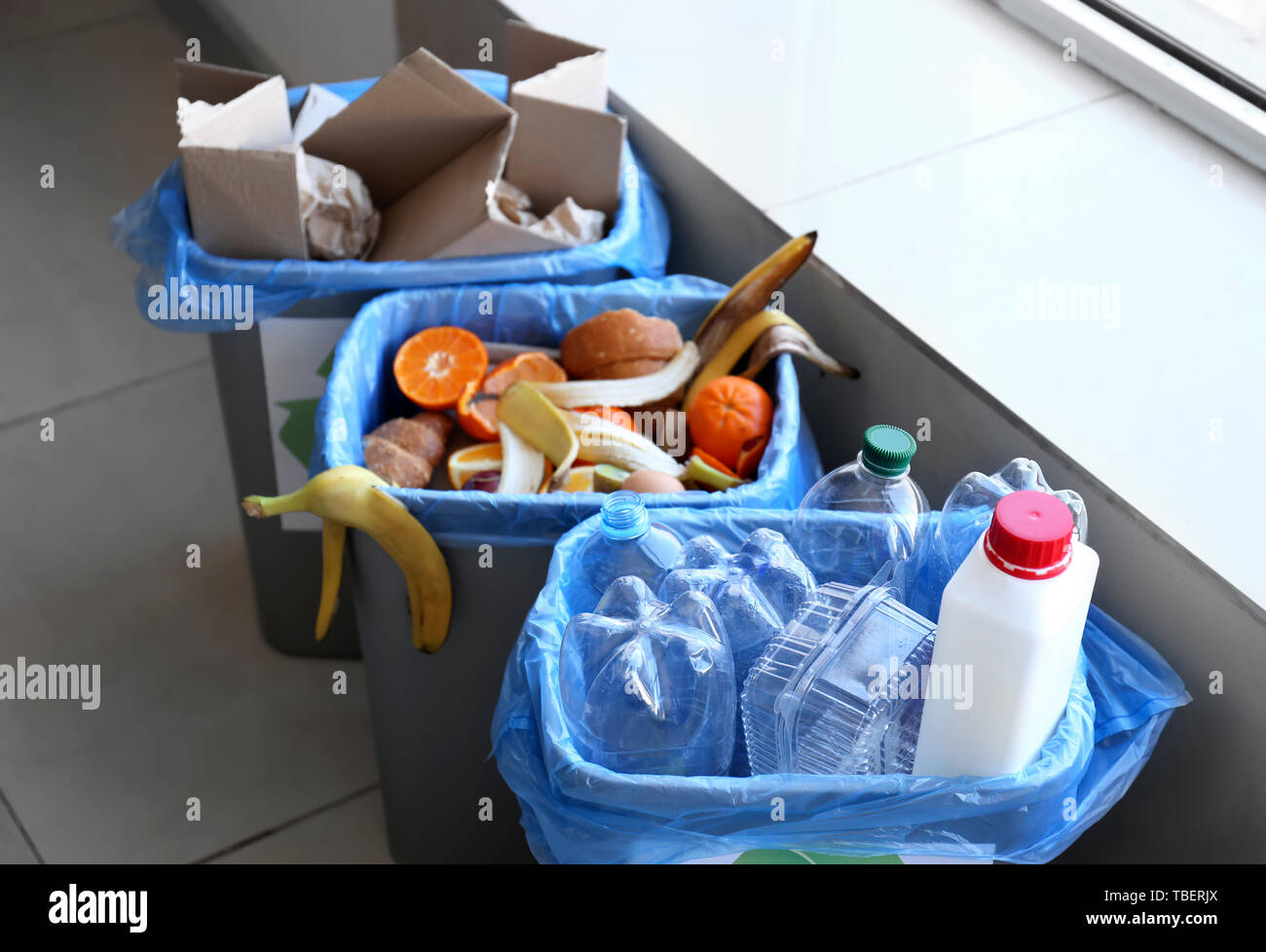 Trash bins with different types of garbage indoors Stock Photo - Alamy