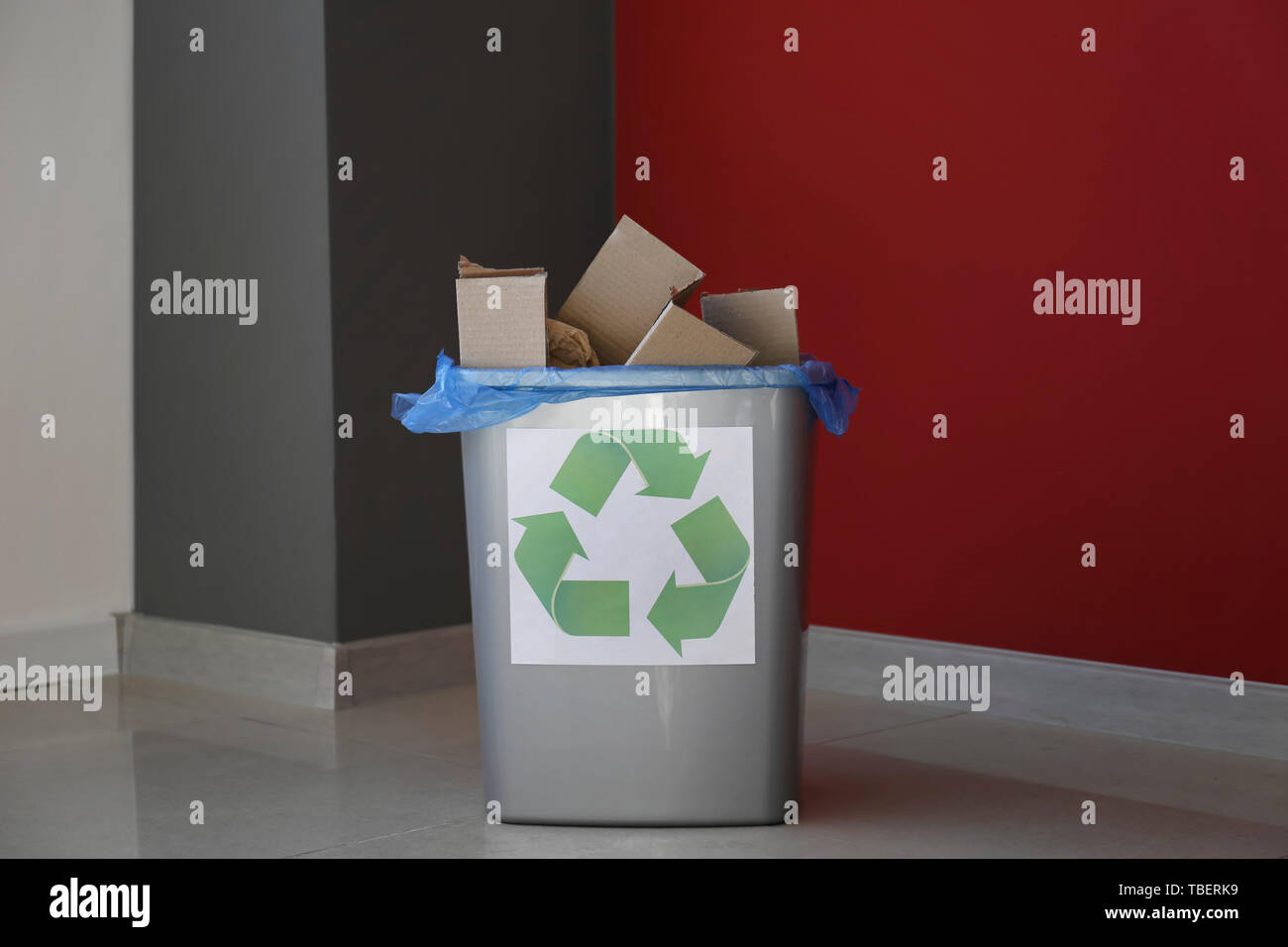 Trash bin with garbage indoors Stock Photo - Alamy