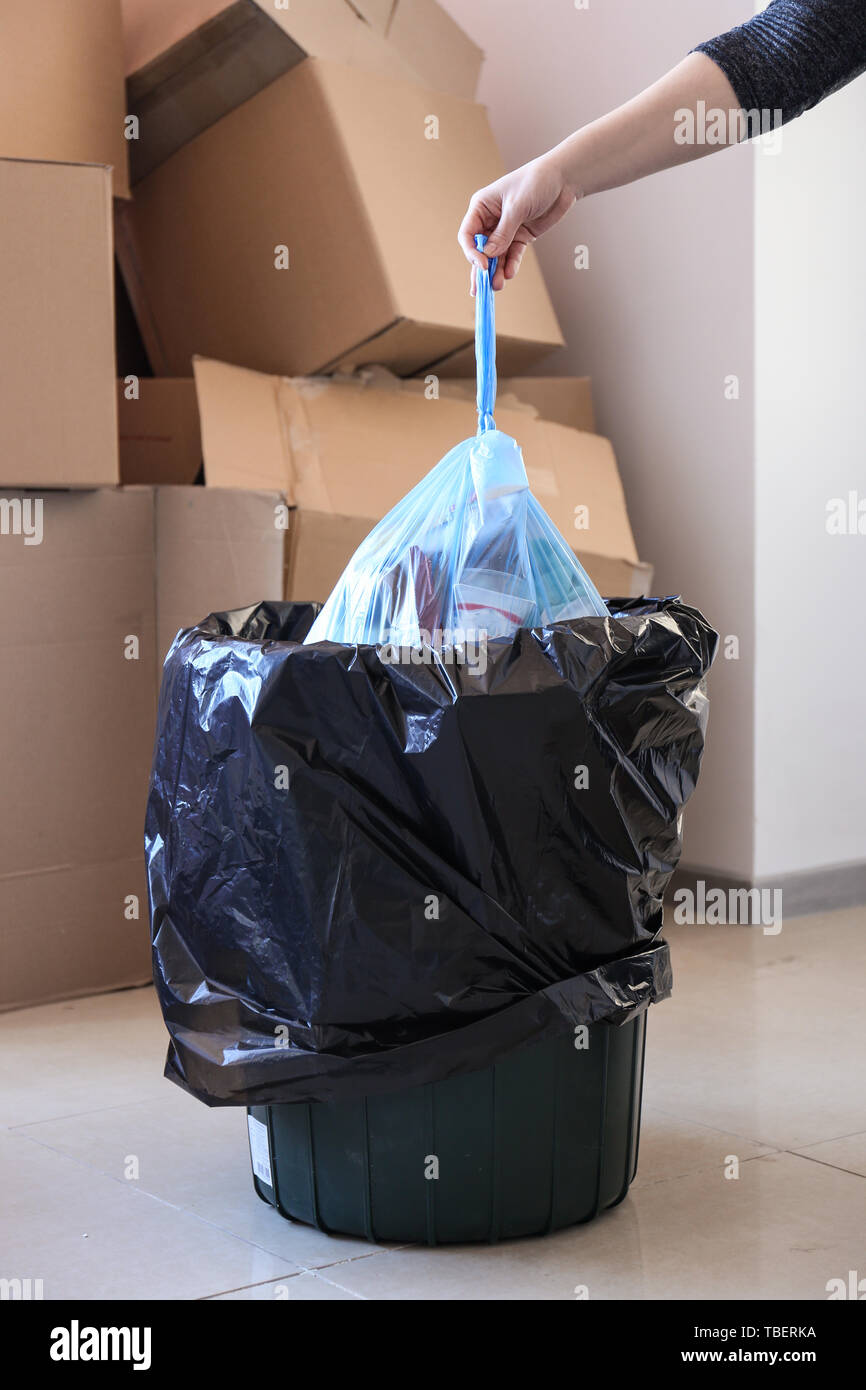 Woman throwing garbage in trash bin Stock Photo - Alamy