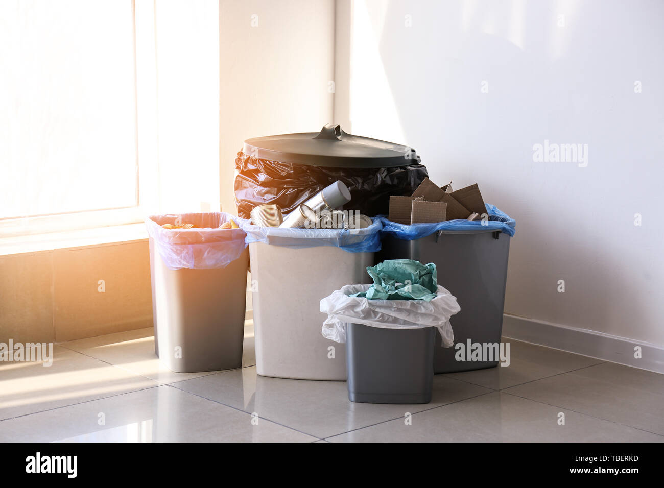 Trash bins with different types of garbage indoors Stock Photo - Alamy