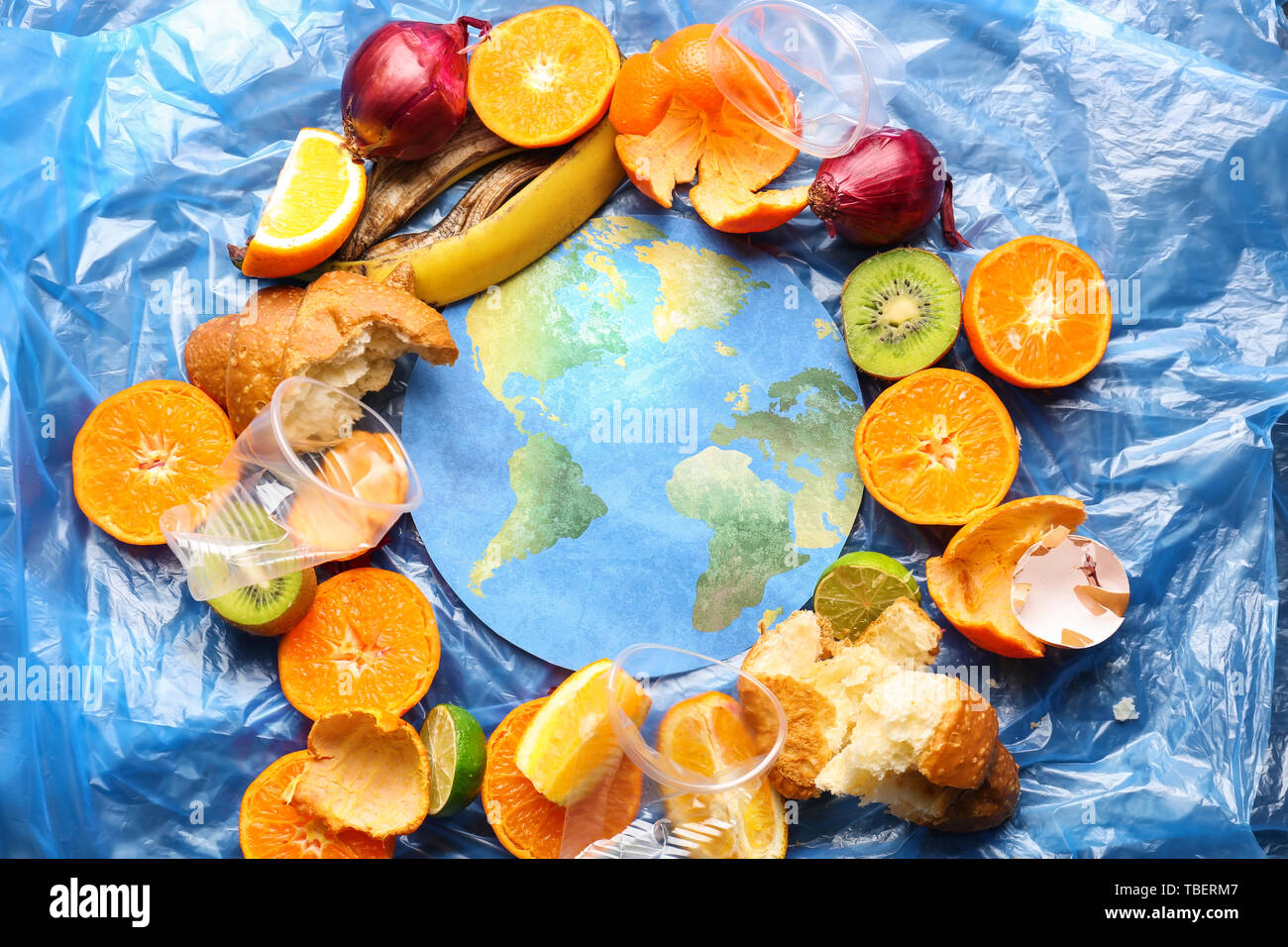 Paper figure of earth and garbage on polyethylene film. Concept of ...