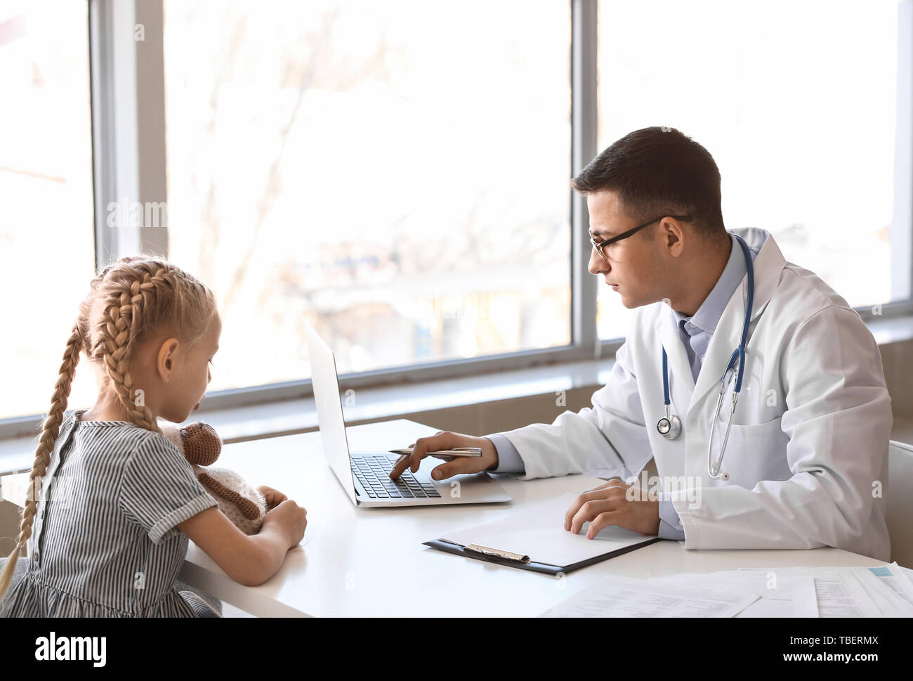 Pediatrician with little girl in his office Stock Photo - Alamy