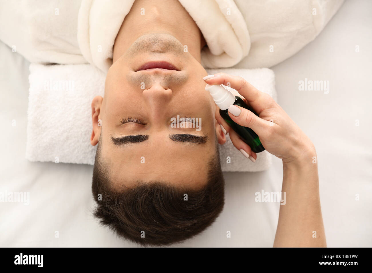 Man undergoing treatment with face serum in beauty salon Stock Photo ...