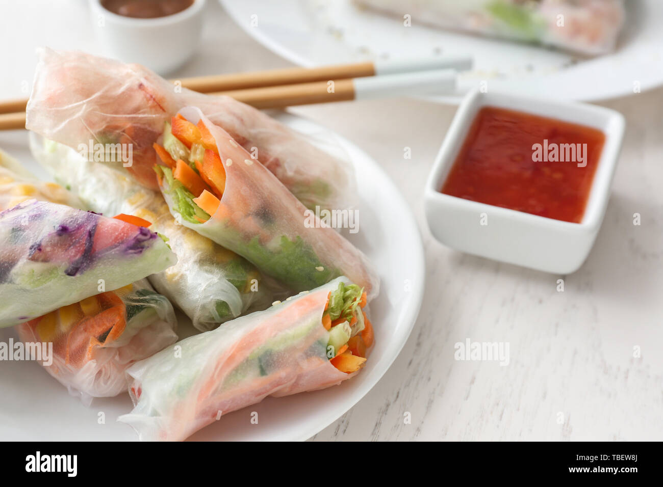 Tasty spring rolls with sauce on table Stock Photo - Alamy