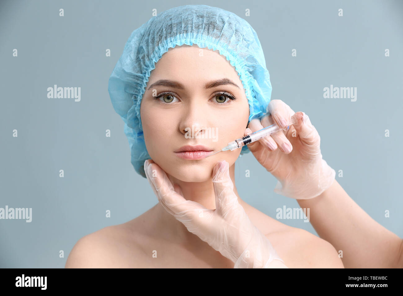 Young woman receiving injection in face on color background Stock Photo ...