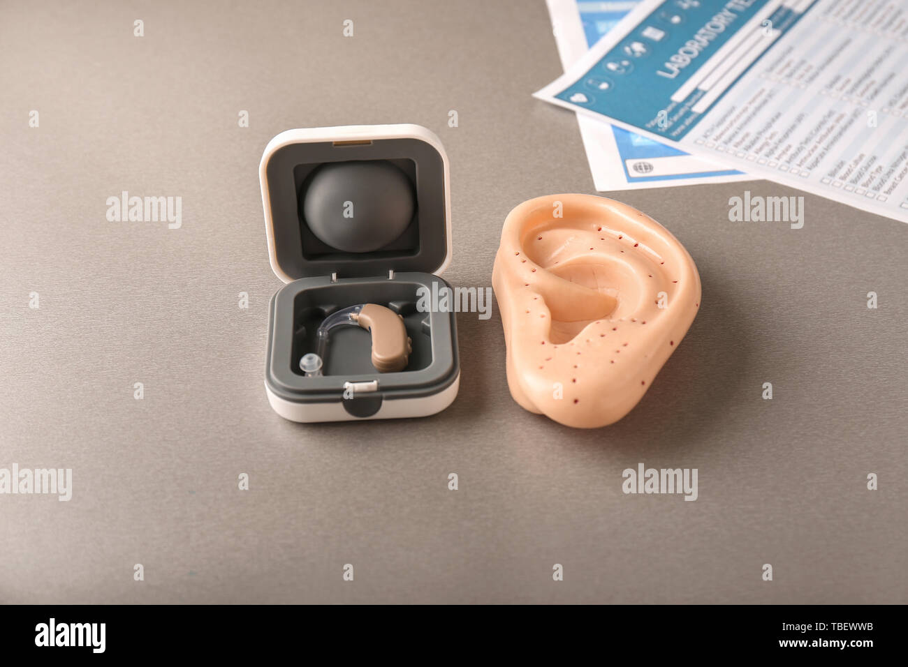 Box with hearing aid and model of ear on grey background Stock Photo ...