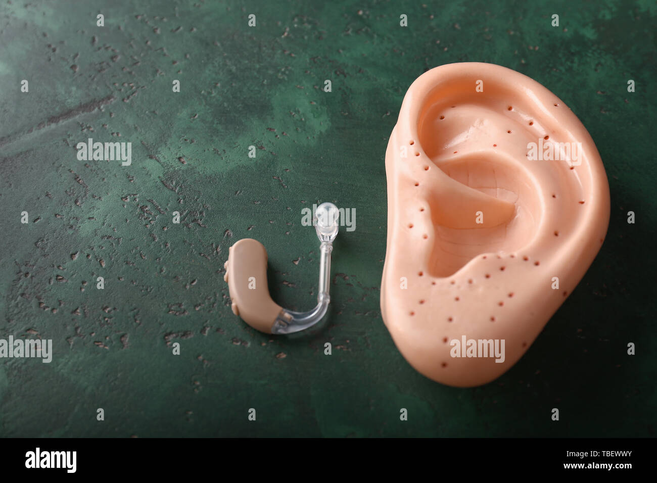 Hearing aid and model of ear on color background Stock Photo - Alamy
