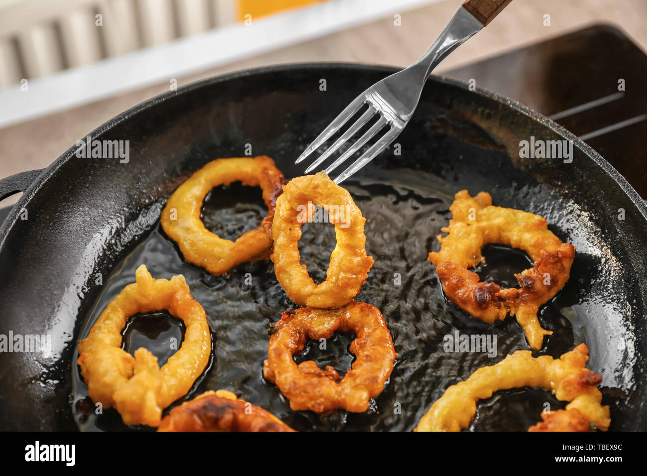 Cooking of tasty onion rings in kitchen, closeup Stock Photo - Alamy