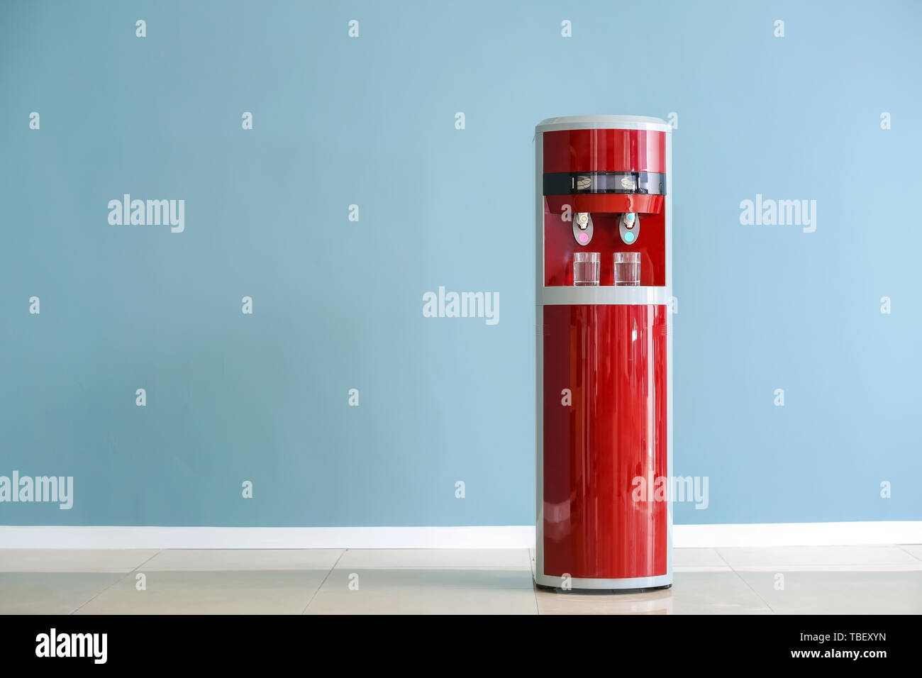 Modern water cooler near color wall Stock Photo - Alamy