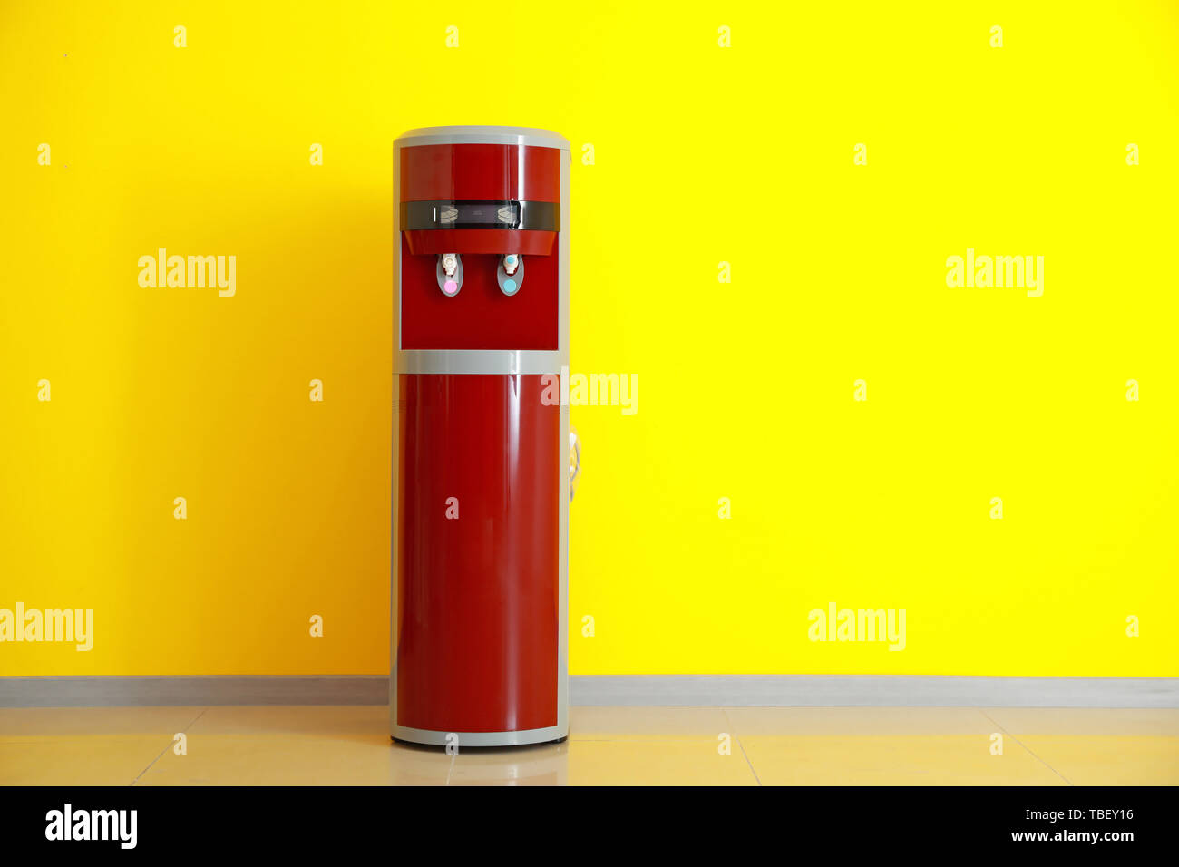 Modern water cooler near color wall Stock Photo - Alamy