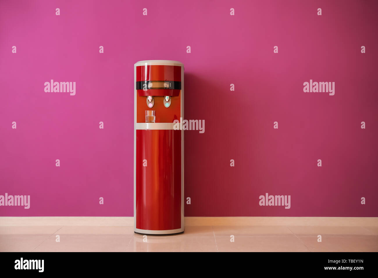 Modern water cooler near color wall Stock Photo - Alamy